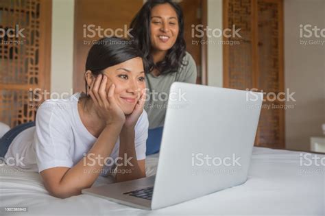 호텔 방에서 친구들과 함께 그룹 비디오 컨퍼런스에 있는 두 명의 아시아 친구들 노트북에 대한 스톡 사진 및 기타 이미지 노트북 침대 휴가 Istock