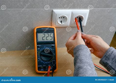 Woman With A Multimeter Check The Voltage Of The Electrical Network Woman Checking Voltage In