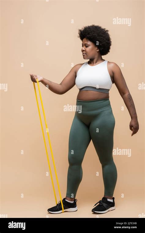 Full Length Of Curly African American Plus Size Woman In Sportwear