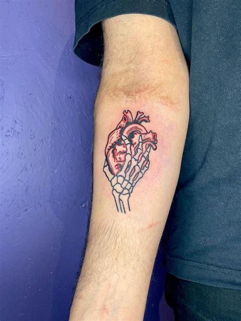 Hand Holding Heart Traditional Tattoo