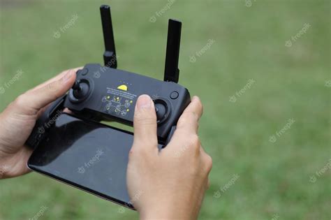 Premium Photo A Man Holds A Remote Controller With His Hands And Controls The Drone