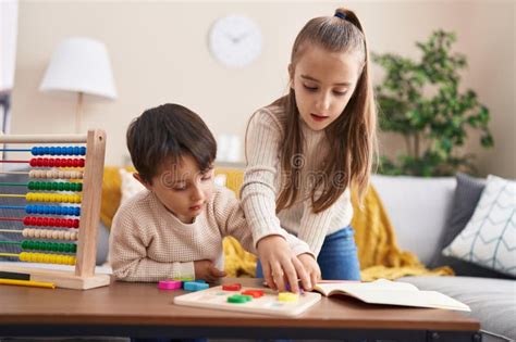Adorable Boy And Girl Playing With Maths Puzzle Game Standing At Home