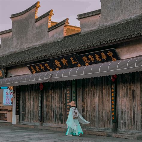 낮 동안 보도를 걷는 녹색 드레스를 입은 여자 사진 Unsplash의 무료 관광객 이미지