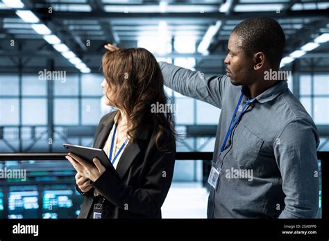 Coworkers Holding Tablet Looking Around Data Center Managing Server