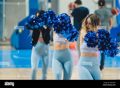 Three Cheerleader Girls Performing Dance Elements Together With Pompons