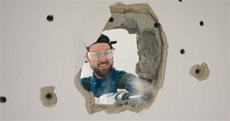 Detail View Of A Construction Worker Using A Handheld Demolition Hammer And Wall Breaker To Chip