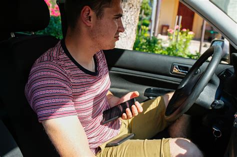 심각한 성공적인 백인 젊은 남자 차에 앉아 전화를 들고 20 대 남자 실버 그레이 그레이 자동차 매력적인 갈색 머리 남자 에 차량 구매자 또는 자동 딜러 개념 첫 번째