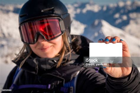 정면도 지도를 보여주는 행복한 미소 짓는 여자 스키어의 초상화 스키 패스 눈 덮인 산을 배경으로 슬로프를 지나간다 신용 카드에