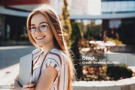 젊은 빨간 머리 백인 여자 들고 노트북 과 보고 카메라 통해 안경을 통해 미소 안경에 대한 스톡 사진 및 기타 이미지 안경 유리잔 여자 Istock