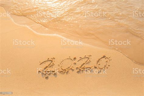 파도와 해변에 문자 바다 해안에 숫자 2020 년 아름다운 해변 배경에 황금 모래에 손으로 메시지 0명에 대한 스톡 사진 및