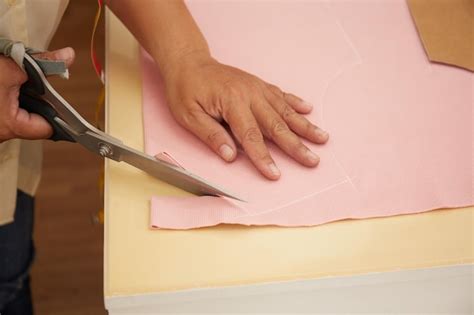 Premium Photo Asian Female Fashion Designer Cutting Material At A