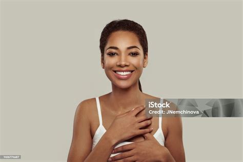 아프리카 계 미국인의 아름다움 회색 배경 위에 카메라에 미소 짓는 깨끗한 피부를 가진 예쁜 흑인 여성의 초상화 18 19세에 대한 스톡 사진 및 기타 이미지 Istock
