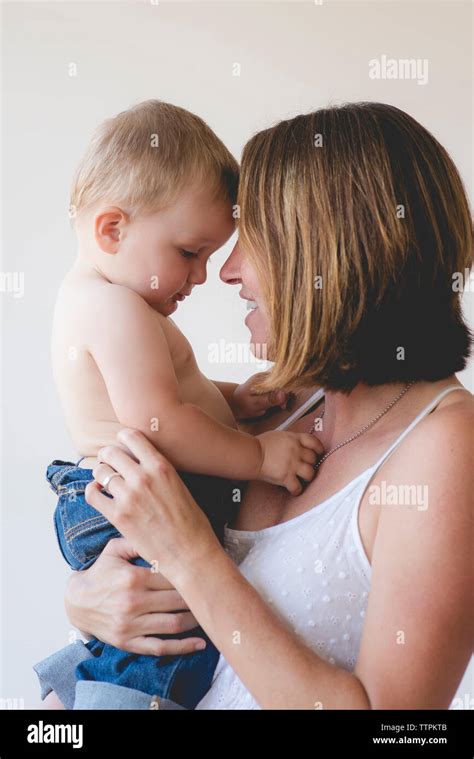 Mother And Shirtless Son Touching Foreheads Against White Background Stock Photo Alamy