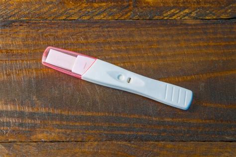 Premium Photo Negative Pregnancy Test On A Dark Wooden Background Close Up