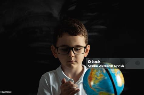 귀여운 백인 여학생이 안경을 쓰고 초등학교 교실에서 검은 학교 게시판에 글로브를 들고 있습니다 학교 개념으로 돌아가기 6 7 살에 대한 스톡 사진 및 기타 이미지 Istock