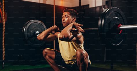 체육관에서 무거운 체중 운동을 하는 근육질의 남자 헬스클럽에서 역도를 하는 청년 사진 Unsplash의 스포츠 이미지