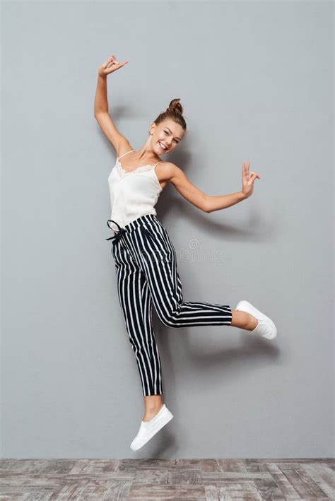 Full Length Portrait Of A Cheerful Cute Woman Jumping Stock Image Image Of Pants Background