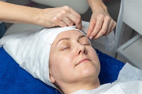 미용사 의사가 노화 방지 시술을 하고 미용클리닉에서 중년 여성 고객을 위한 폼 클렌징 마스크를 적용합니다 미용사 스킨케어 트리트먼트 건강 관리 치료 가리기에 대한 스톡 사진