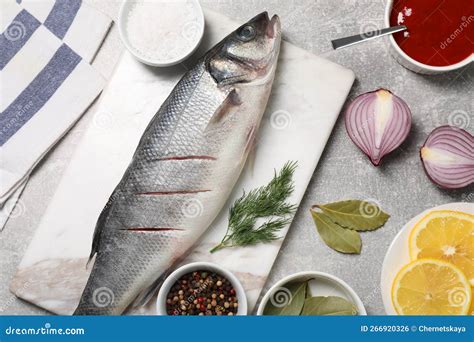 Fresh Raw Sea Bass Fish And Ingredients On Light Gray Table Flat Lay