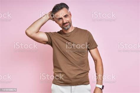 분홍색 배경에 서서 머리 뒤에 손을 잡고있는 잘 생긴 성숙한 남자 남자에 대한 스톡 사진 및 기타 이미지 남자 분홍색 배경 성년 남자 Istock