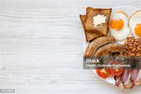 상단 보기 튀김된 계란 베이컨 소시지 콩 토스트와 함께 아침 식사 영어 흰색 나무 배경입니다 공간 및 텍스트 영역을 복사 합니다