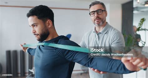 물리 치료 저항 밴드 및 재활 건강 관리 또는 스트레칭을 위해 클리닉에서 남성 및 운동 선수와 상담 치유 조언 또는 회복을 위해 사람들과 함께 지원 의료 및 근육 건강관리와