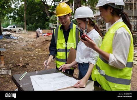 Structural Engineer And Architect Discussing And Working With Blueprints At The Outdoors