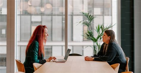 노트북을 들고 테이블에 앉아 있는 두 명의 여성 사진 Unsplash의 사무실 이미지