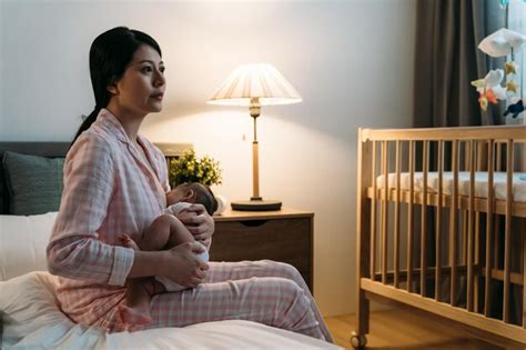 Premium Photo Portrait Loving Asian Mom Sitting At Bedside In Pajamas