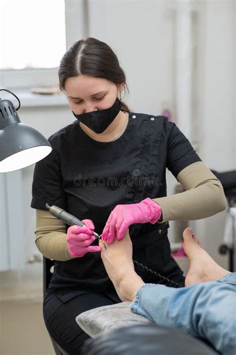 The Pedicure Master Processes The Clientand X27s Foot Using An Apparatus With An Abrasive Disc