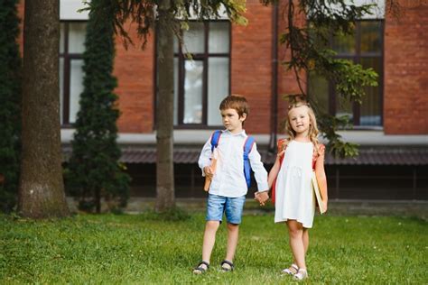 행복한 아이들 첫 학교 날에 책과 배낭을 가진 소년과 소녀 방학 후 학교로 돌아 오게되어 기쁩니다 전체 길이의 야외 초상화 2명에 대한 스톡 사진 및 기타 이미지 Istock