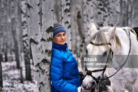 겨울 자작나무 숲에는 화이트와 블루 재킷과 산책 스포츠 모자에 젊은 예쁜 여자 걷기에 대한 스톡 사진 및 기타 이미지 걷기 겨울 눈 신체 부분 Istock