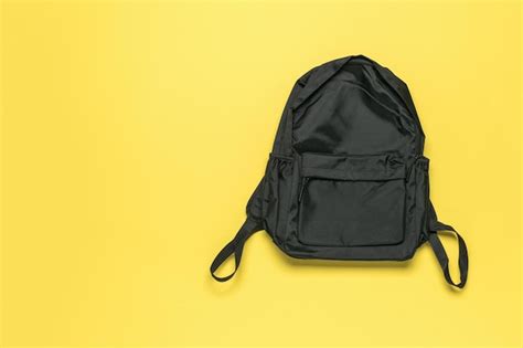 Premium Photo Stylish Black Backpack On A Yellow Background