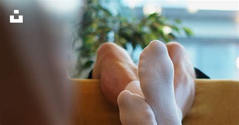 Una persona acostada en un sofá con los pies en alto foto – Imagen de ...