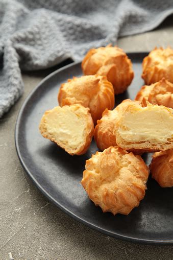 회색 배경에 접시에 크림이 있는 수제 수익 창출 갓 구운 황금 프로피테롤 세로 사진 갈색에 대한 스톡 사진 및 기타 이미지 갈색 노랑 달콤한 음식 Istock