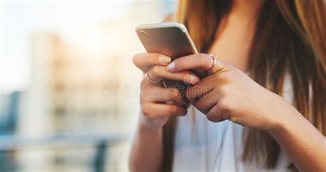 Updating Her Status An Unrecognizable Young Woman Sending A Text Updating Her Status An Unrecognizable Young Woman Sending A Text