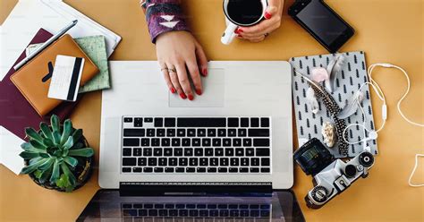 세련된 노트북 펜 전화와 공예 배경 소녀 손에 즙이 많은 커피를 들고 휴가와 프리랜서 개념을 계획하고 플랫 레이 사진