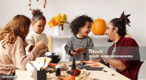 집에서 할로윈을 준비하는 젊은 즐거운 아프리카 계 미국인 가족 어머니 아버지와 두 자녀 사탕주면 안 잡아먹지에 대한 스톡 사진 및 기타 이미지 사탕주면 안 잡아먹지