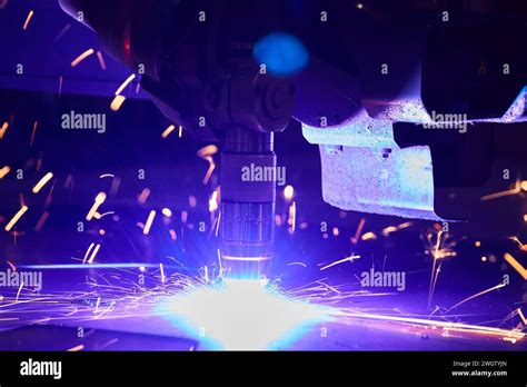 Robotic Arm Welding In Industrial Setting With Dynamic Sparks Stock