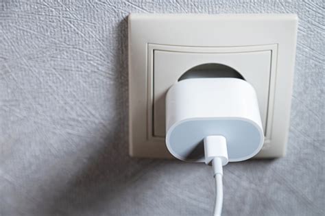 분홍색 벽에 전기 소켓 검은색 와이어 플러그가 연결되어 있습니다 스튜디오 아파트의 개조 된 배경 빈 복사 공간 단일 흰색 플라스틱 소켓 0명에 대한 스톡 사진 및 기타