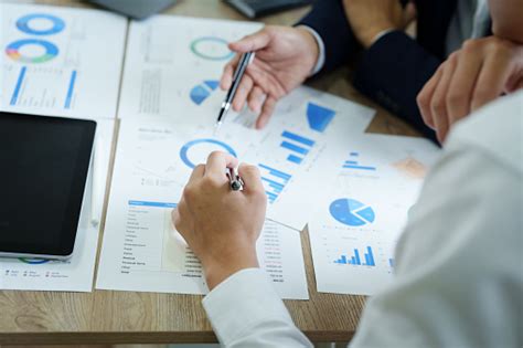 팀워크 개념 상담 남성 경제학자들이 펜을 들고 예산 재정 및 투자 문서를 가리키며 회의실에서 여성 고문들과 재정을 논의하고 계획합니다 금융에 대한 스톡 사진 및 기타 이미지