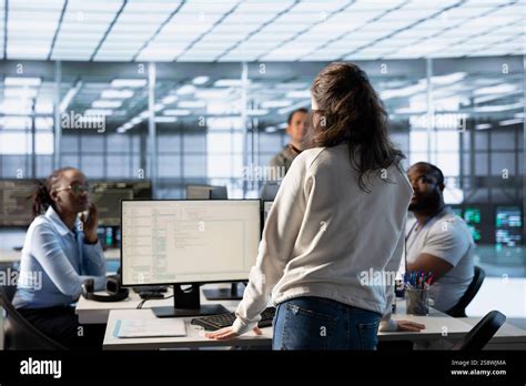 Manager Supervising Multiethnic Team Working In Data Center Raising From Desk To Make