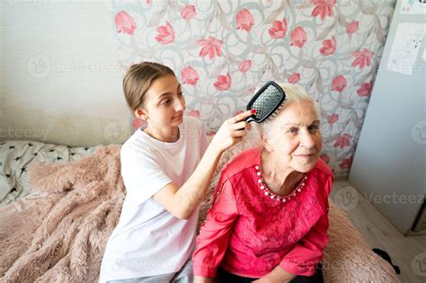 Joyful Moments Of A Young Girl Brushing The Hair Of Her Grandmother In