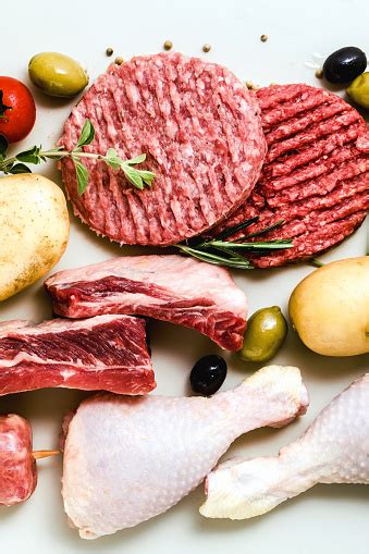 다양 한 종류의 생고기 닭고기 허벅지 돼지고기와 쇠고기 버거 갈비와 케밥 칠면조 미트볼 감자 고추 올리브 및 검은 올리브와