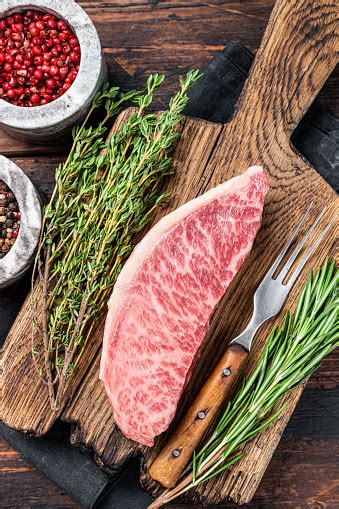 와규 A5 생 럼프 또는 등심 스테이크 정육점 판에 고베 쇠고기 고기 어두운 나무 배경 위쪽 보기 스트립 스테이크에 대한 스톡