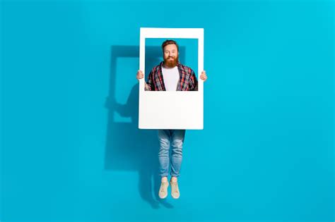 좋은 기분의 낙관적인 남자가 격자 무늬 셔츠 바지 팔을 들고 파란색 배경에 고립된 사진 프레임 점프를 하는 전체 길이 사진 35 39세에 대한 스톡 사진 및 기타 이미지