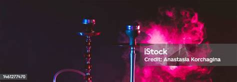 Modern Hookah Shisha On A Smoky Black Background With Neon Lighting And