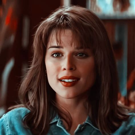 A Close Up Of A Person Wearing A Blue Shirt And Orange Lipstick On Her Lips