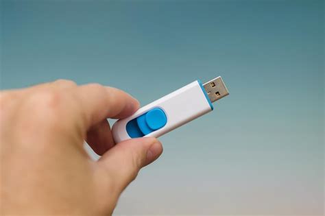 Premium Photo Digital Data Memory Hand Holding Usb Flash Drive On Blue Background