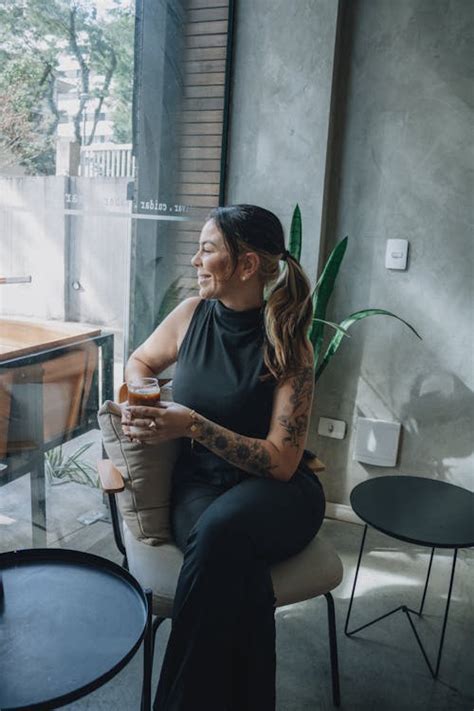 Женщина наслаждается кофе в стильном современном кафе · Бесплатные стоковые фото